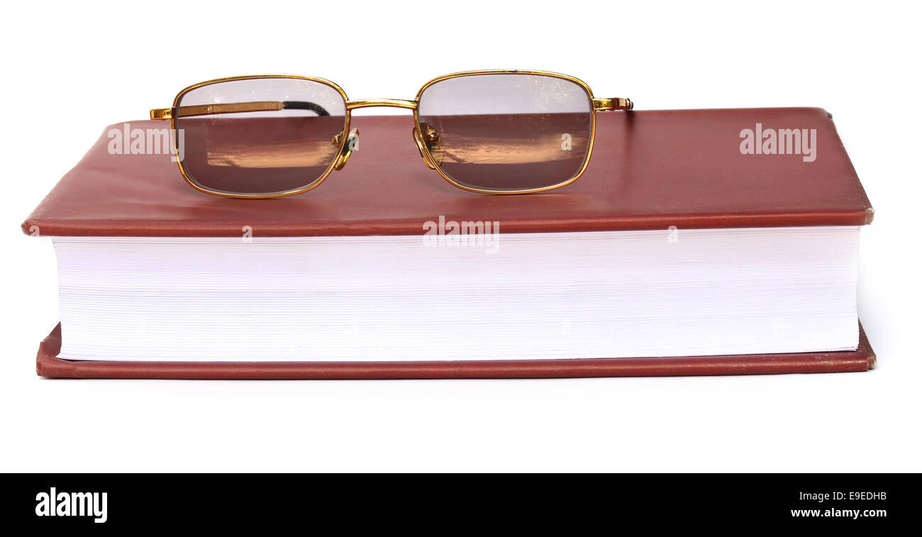 Spectacles on a book over white background Stock Photo - Alamy