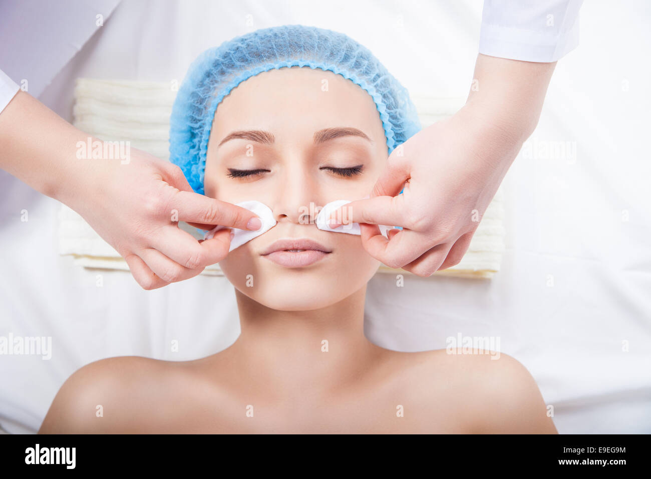 Skin care - woman cleaning face by beautician over white background ...