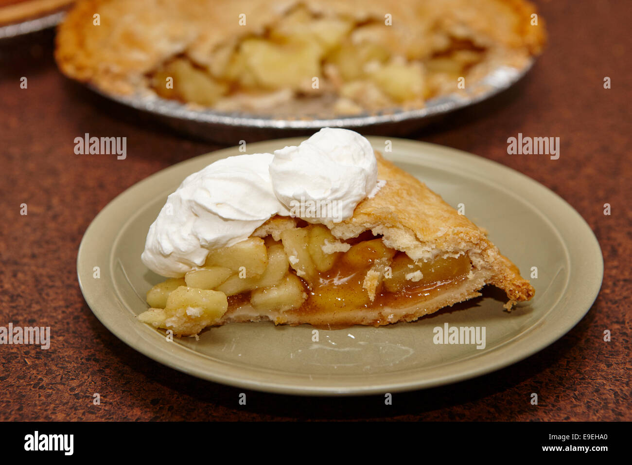 large slice of mass produced apple pie with whipped cream topping Stock ...