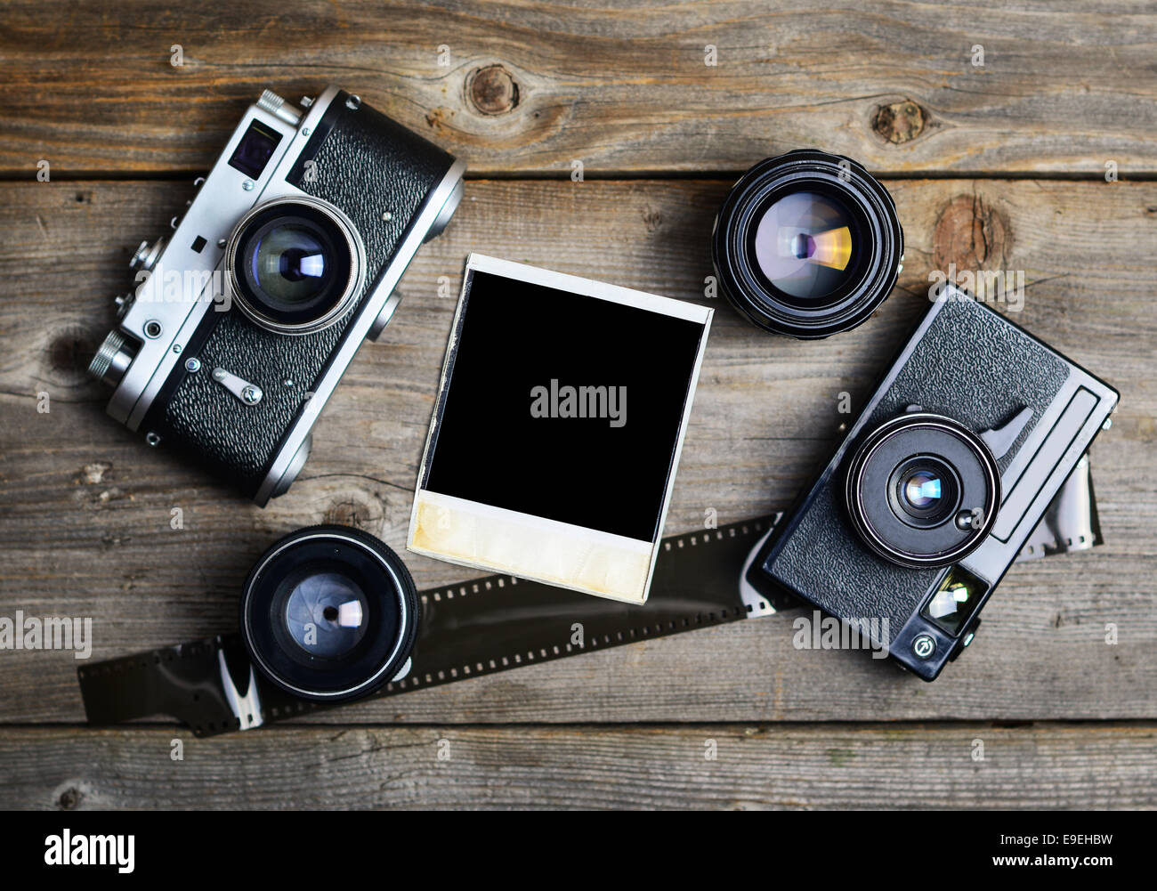Vintage cameras around empty retro photograph on wooden background ...