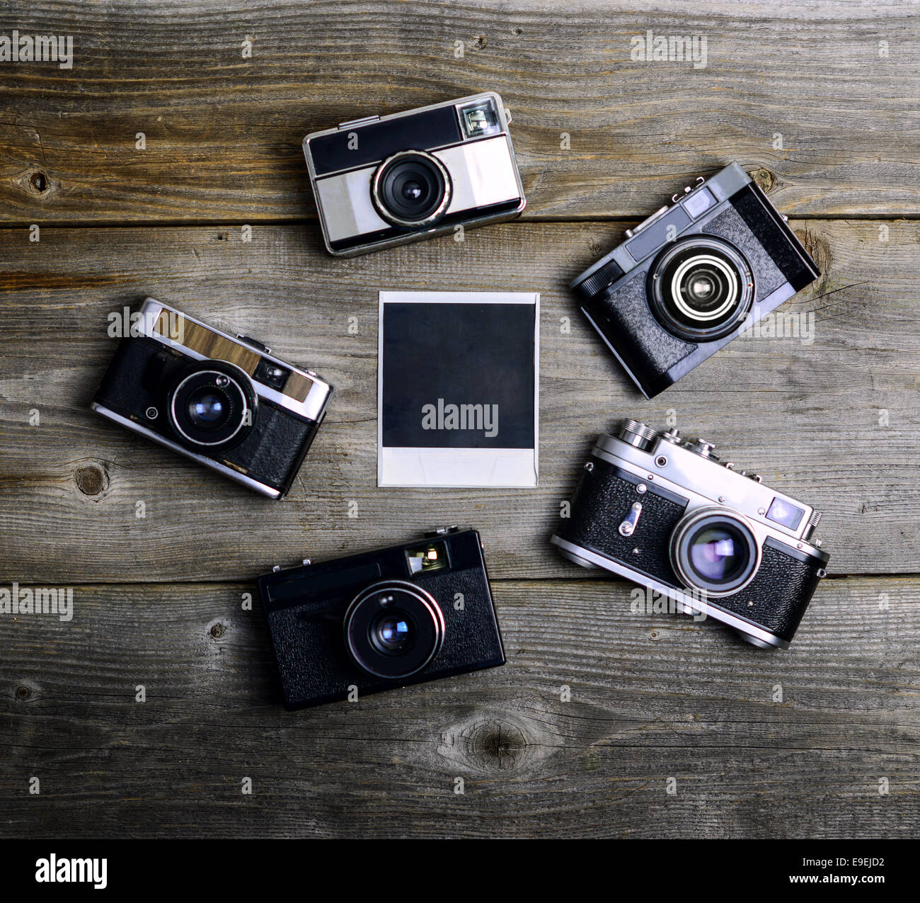 Vintage cameras around empty retro photograph on wooden background ...