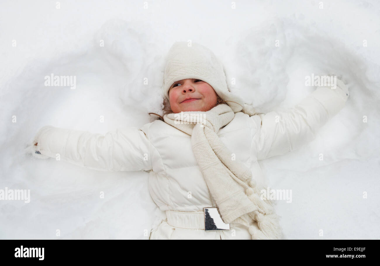 Happy cute little girl in winter park. Snow angel Stock Photo - Alamy
