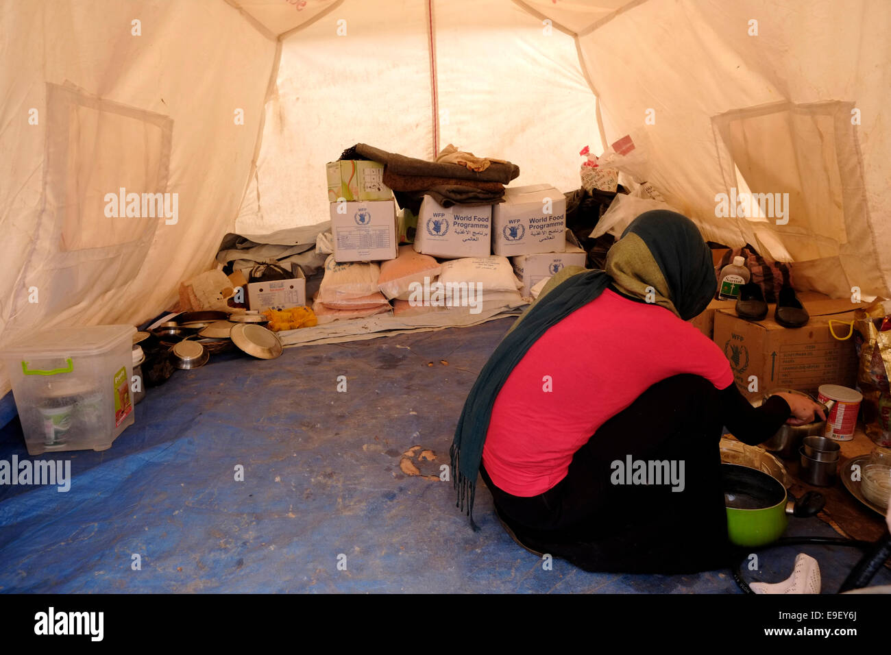 A Yazidi woman siting inside a temporary shelter tent at a refugee camp ...