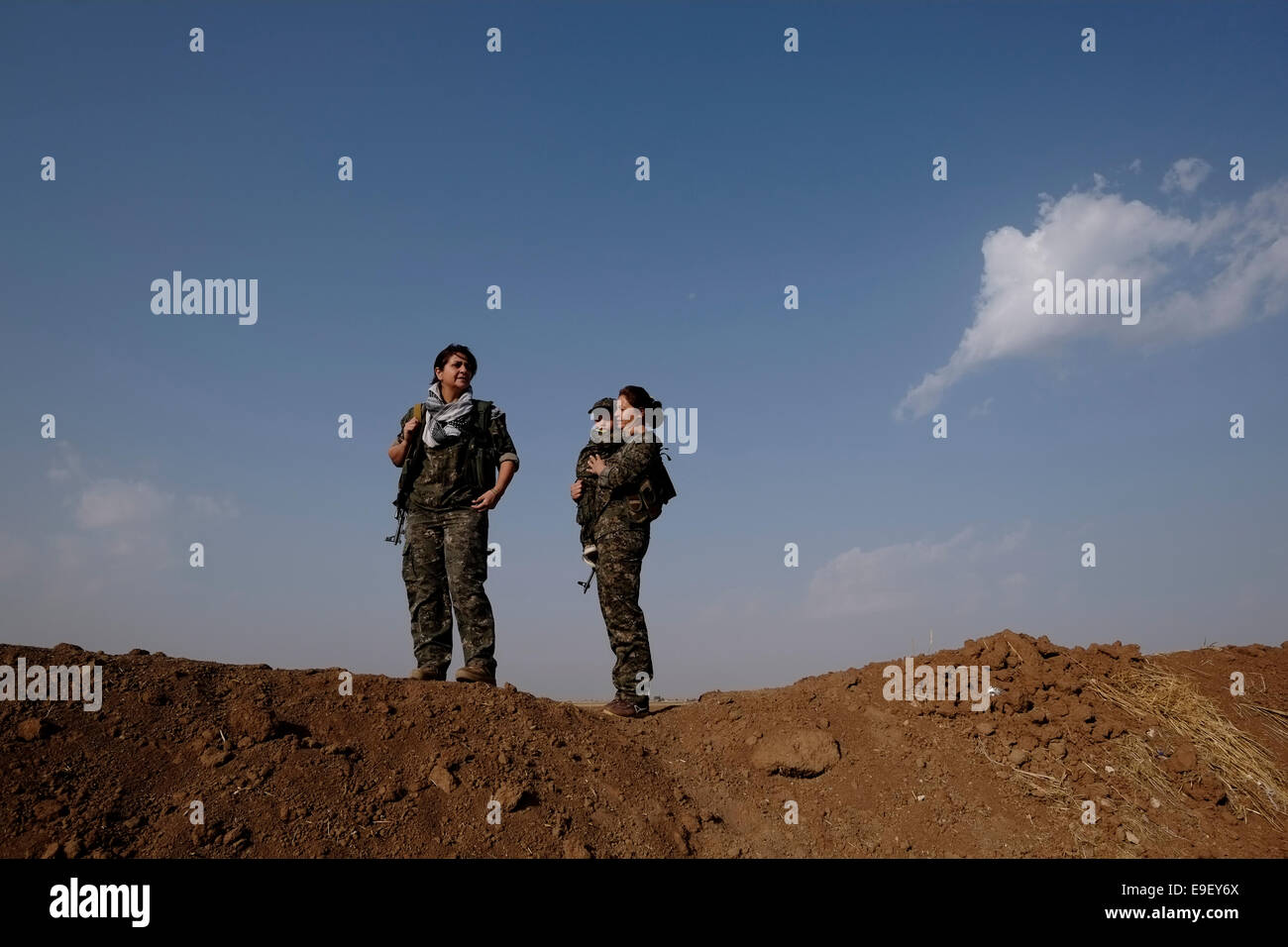 Kurdish fighters from the Women's Protection Units YPJ with a young boy ...