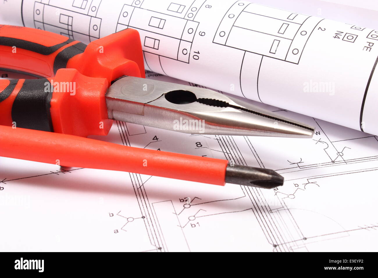 Rolled electrical diagrams with work tools lying on construction ...