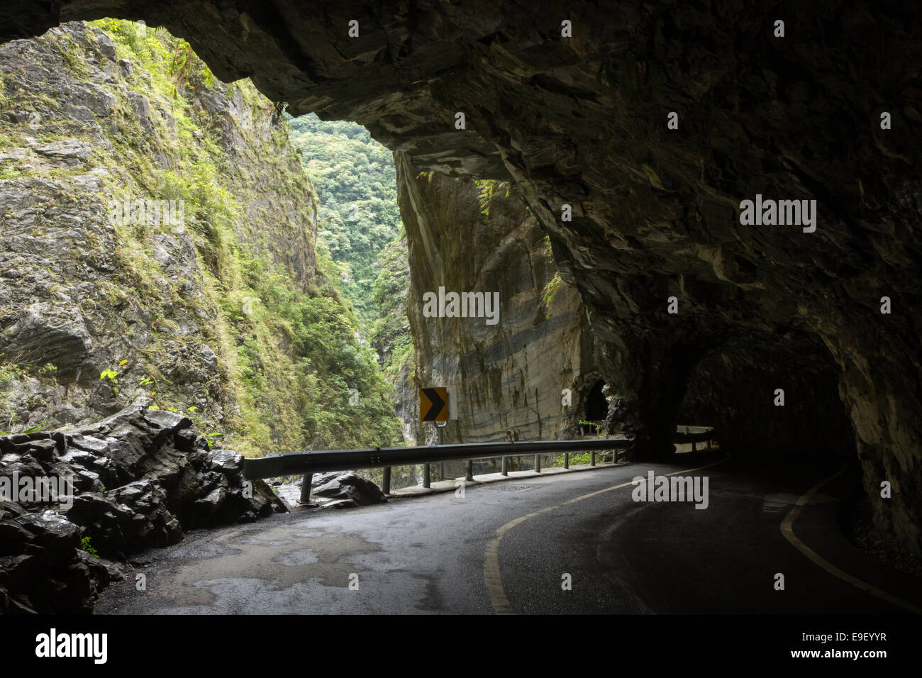 Steep rocks, deep and narrow gorge and small road dug into rock at ...