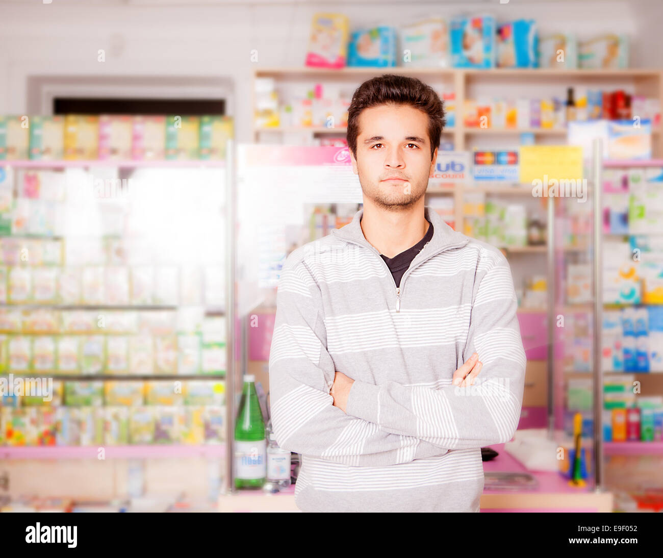 Handsome guy in front of pharmacy stand. Drugs and pills in pharmacy ...