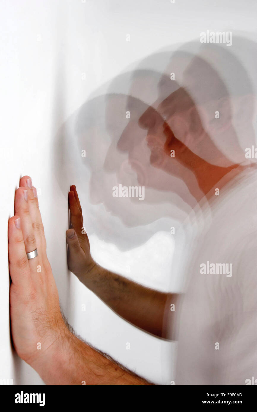 a man bangs his head against a wall in frustration Stock Photo - Alamy