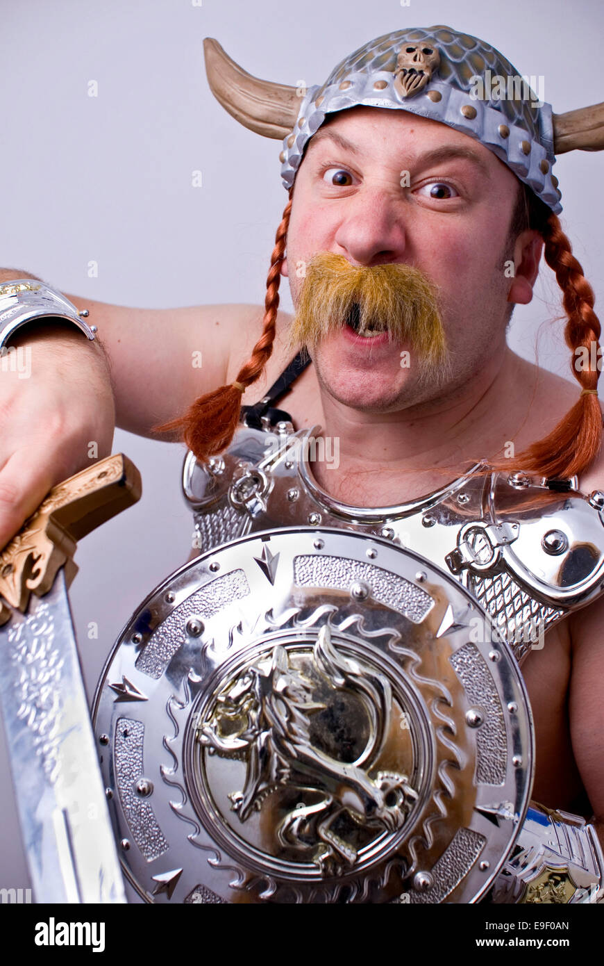 a man in fancy dress comedy costume dressed as a viking in kids armor ...