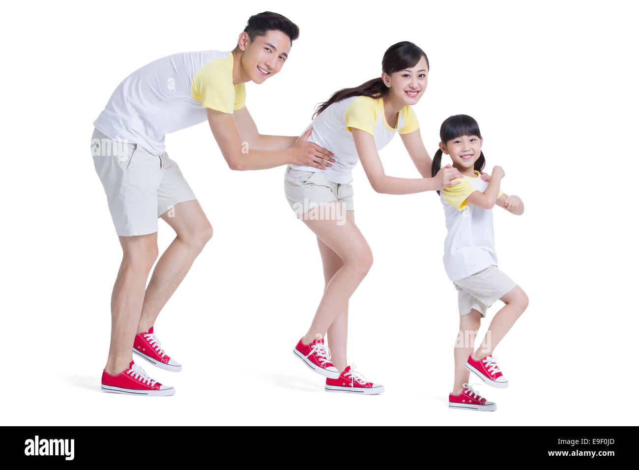 Happy young family walking in train formation Stock Photo - Alamy