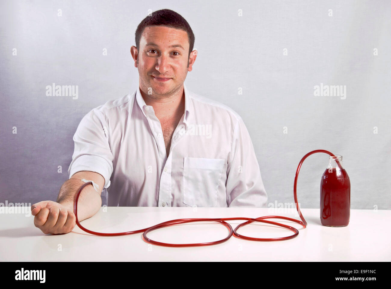 a man in a white shirt looks like he is giving a pint of blood with a ...