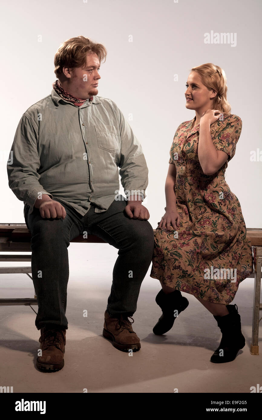man and woman sat on chairs / benches talking to each other in period ...