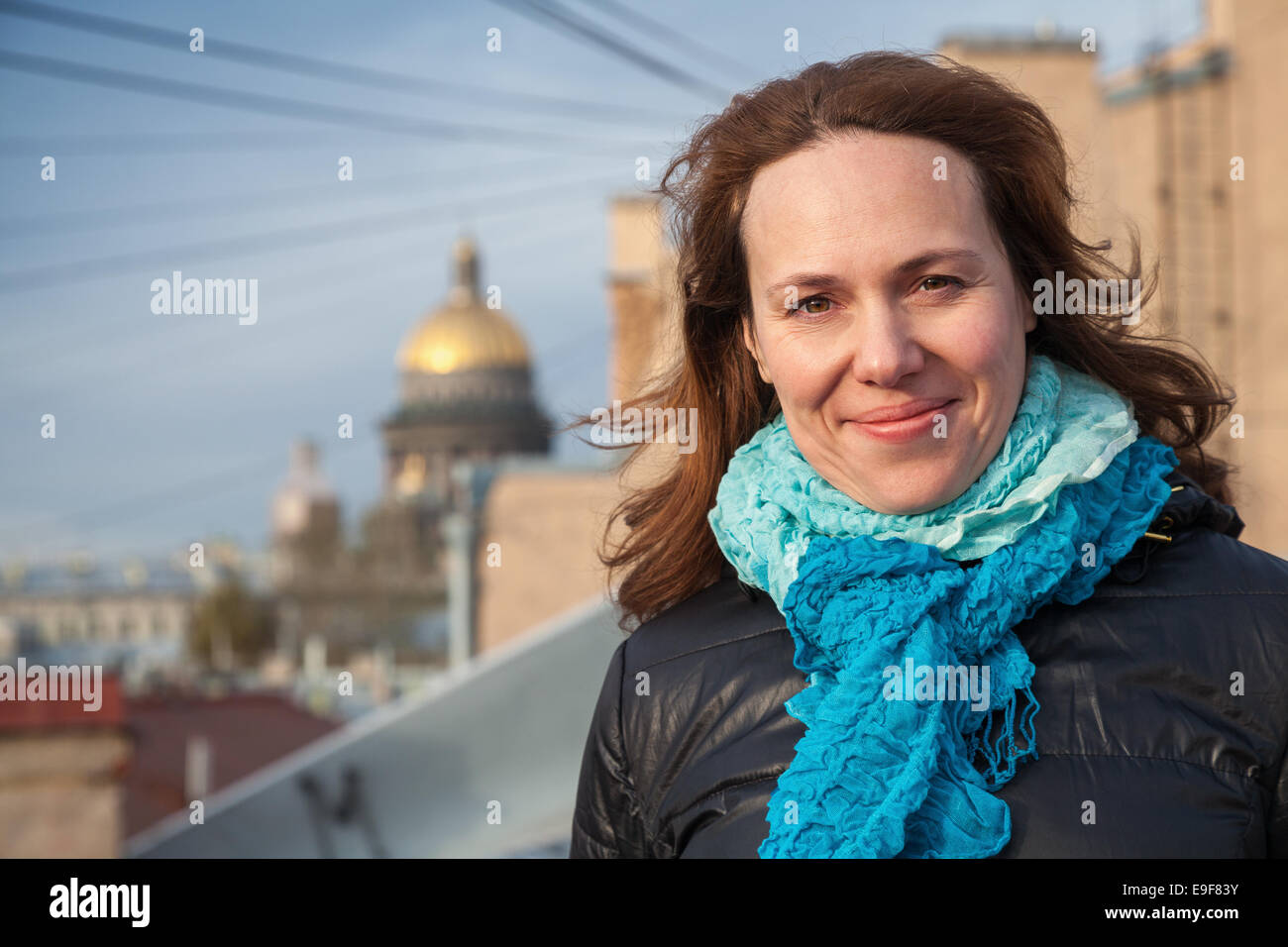 Outdoor portrait of young smiling Caucasian woman on the roof in St ...