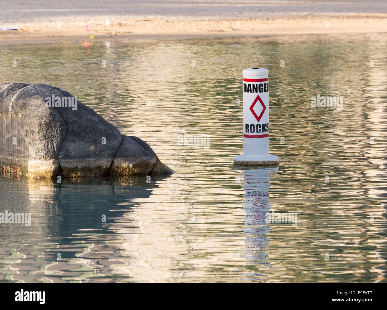 Sign for Danger Rocks in swimming pool Stock Photo - Alamy