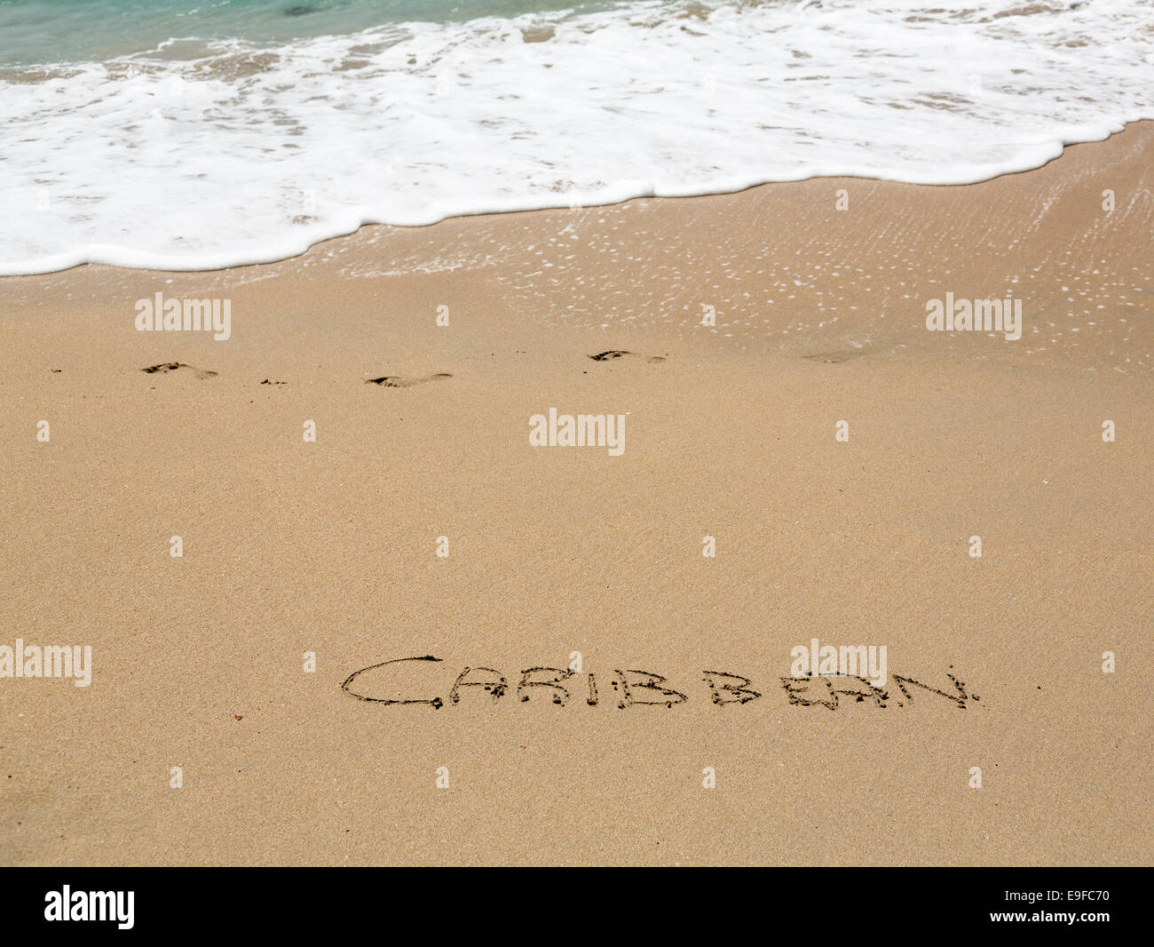 Caribbean written in sand with sea surf Stock Photo - Alamy