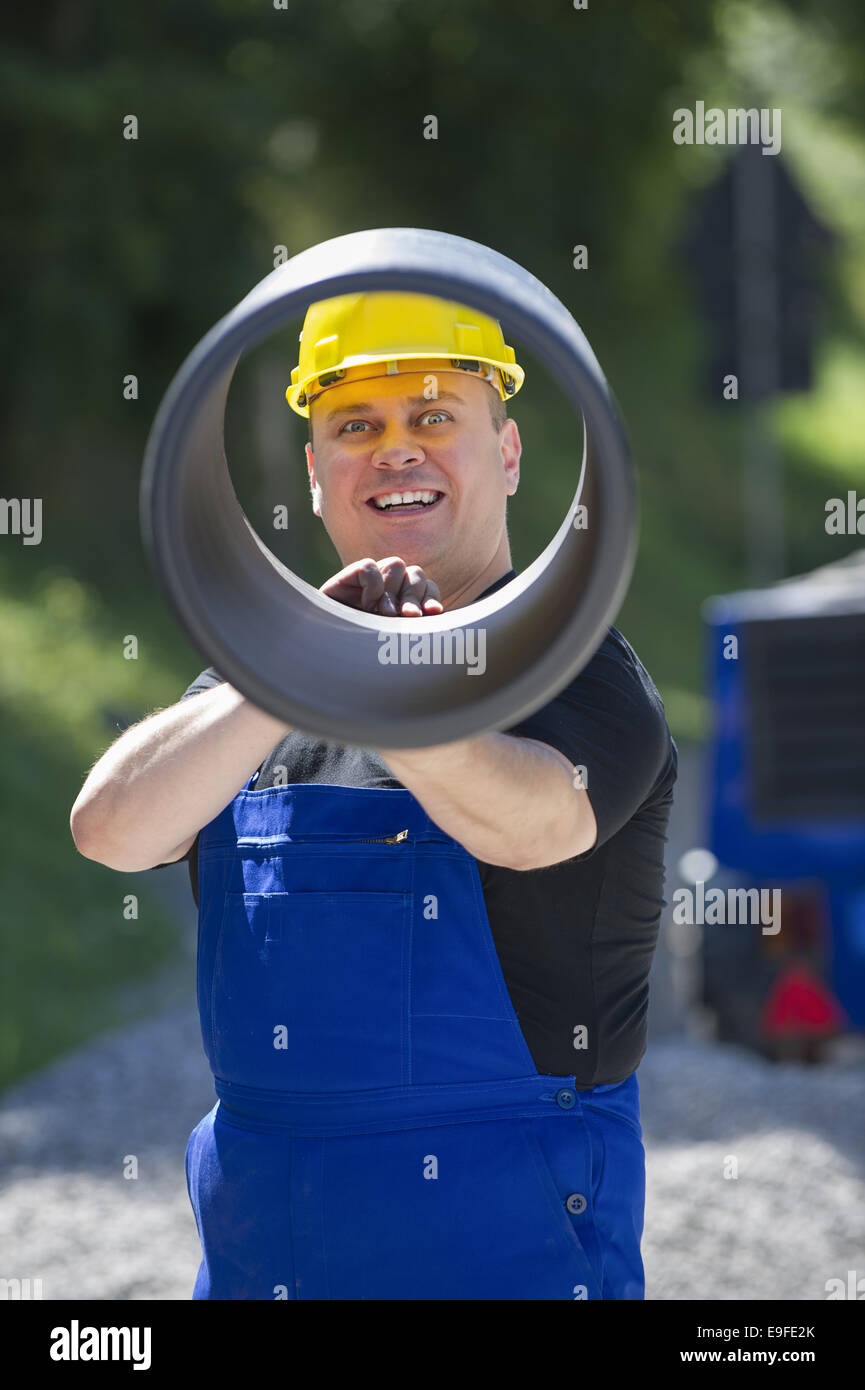 Construction worker with pipe in hand Stock Photo - Alamy
