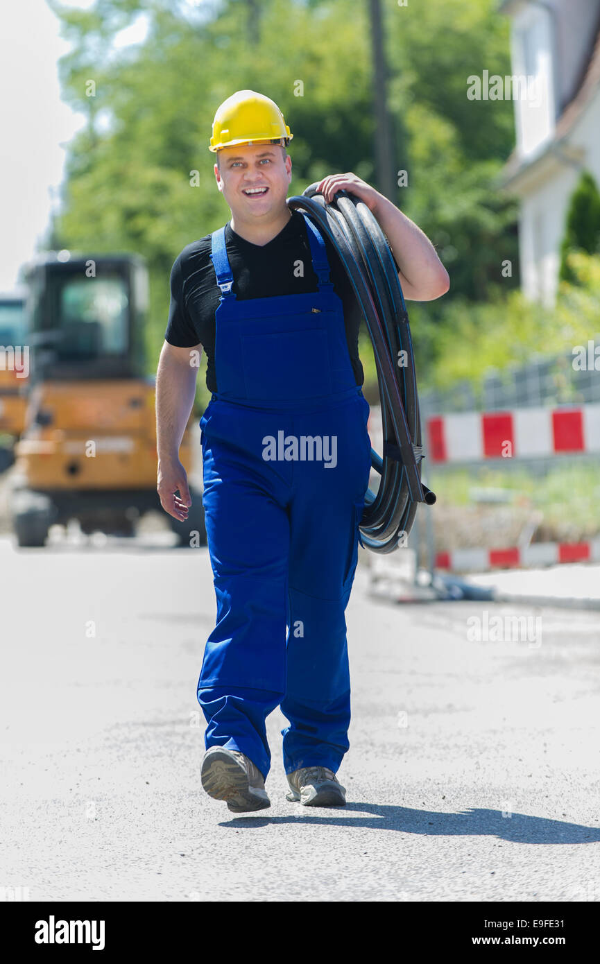 Construction worker with a supply line Stock Photo - Alamy