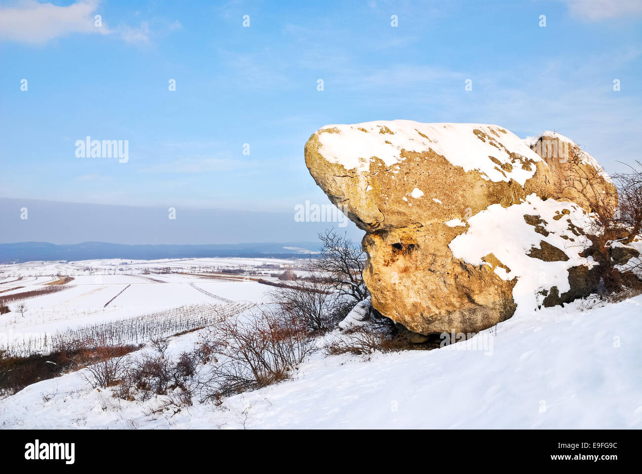 Boulder in snowy winter landscape Stock Photo - Alamy