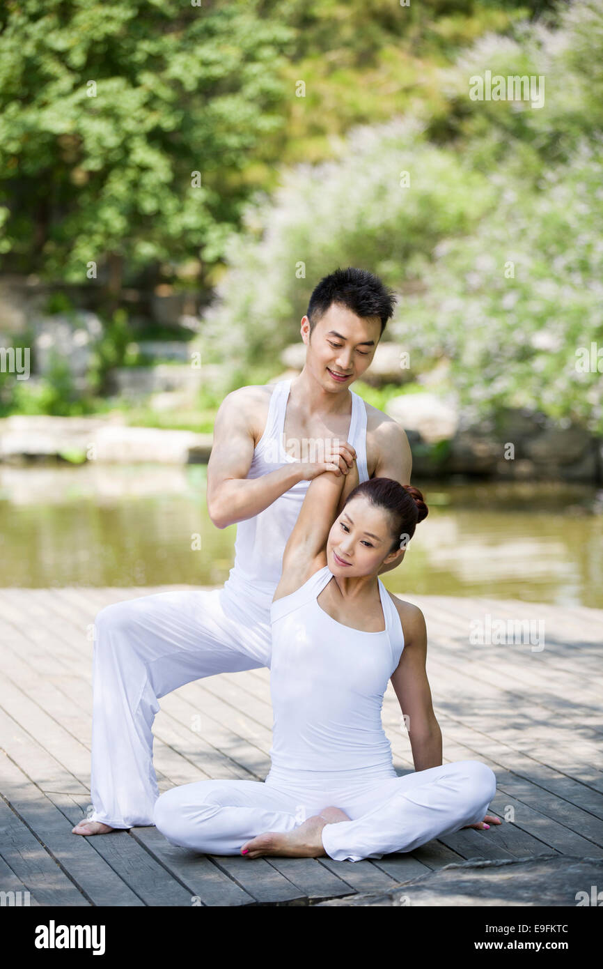 Yoga instructor helping woman with pose Stock Photo - Alamy