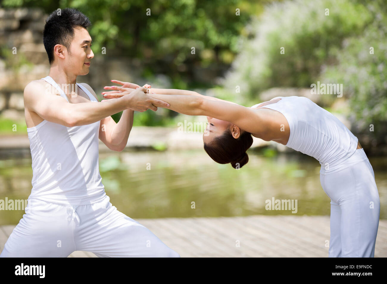 Yoga instructor helping woman with pose Stock Photo - Alamy