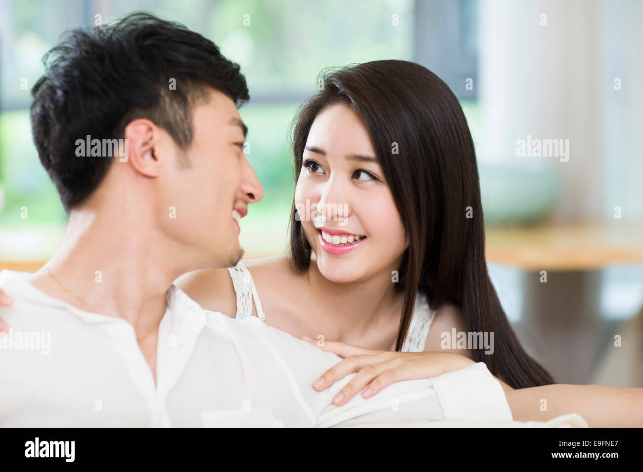 Young couple smiling at each other Stock Photo - Alamy