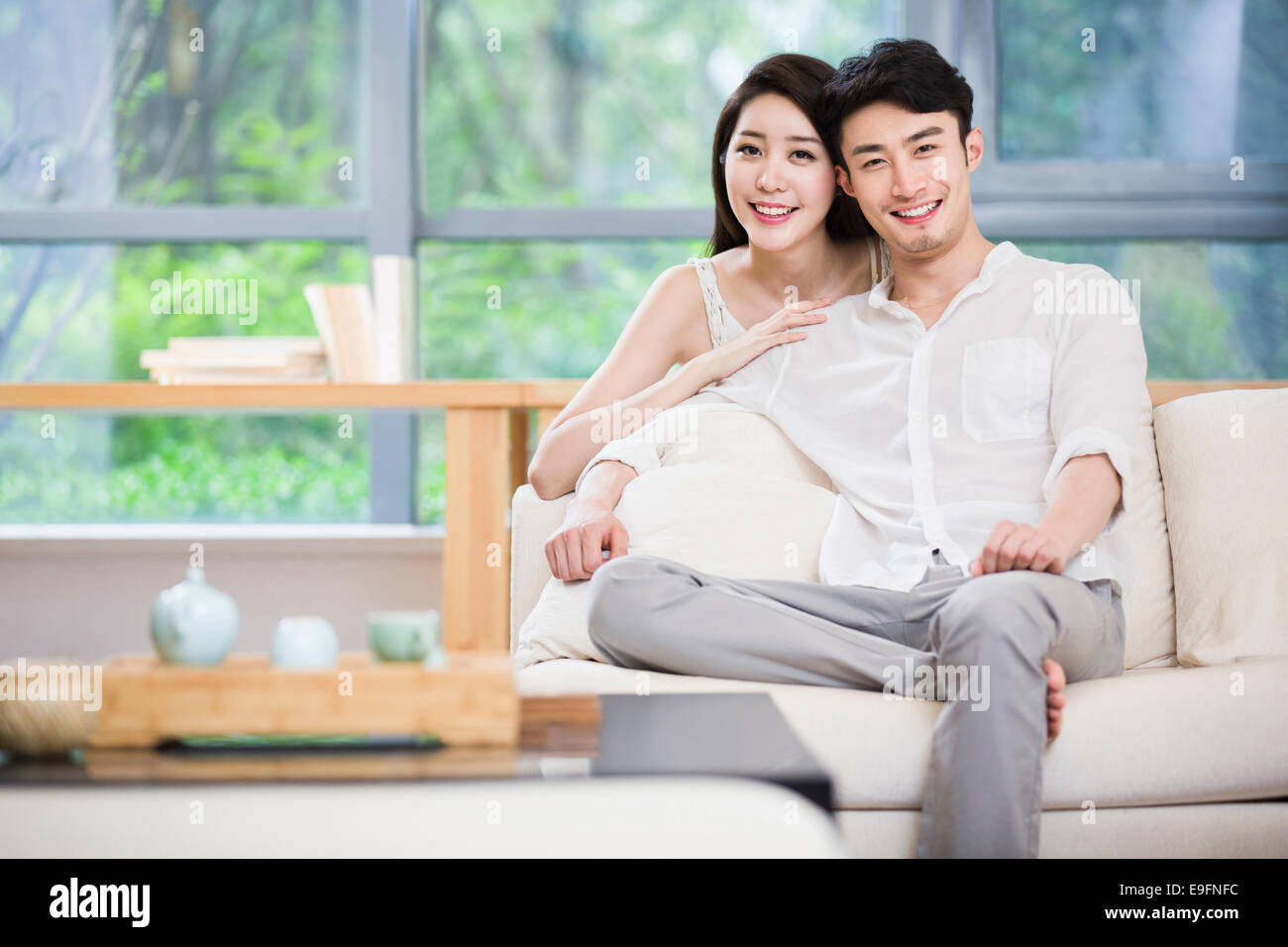 Cheerful young couple in living room Stock Photo - Alamy