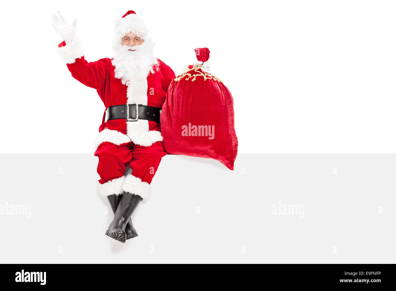 Santa gesturing happiness seated on a panel isolated on white ...
