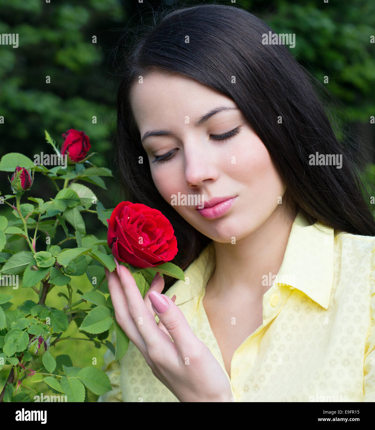 Portrait of Woman with a red rose in the garden Stock Photo - Alamy