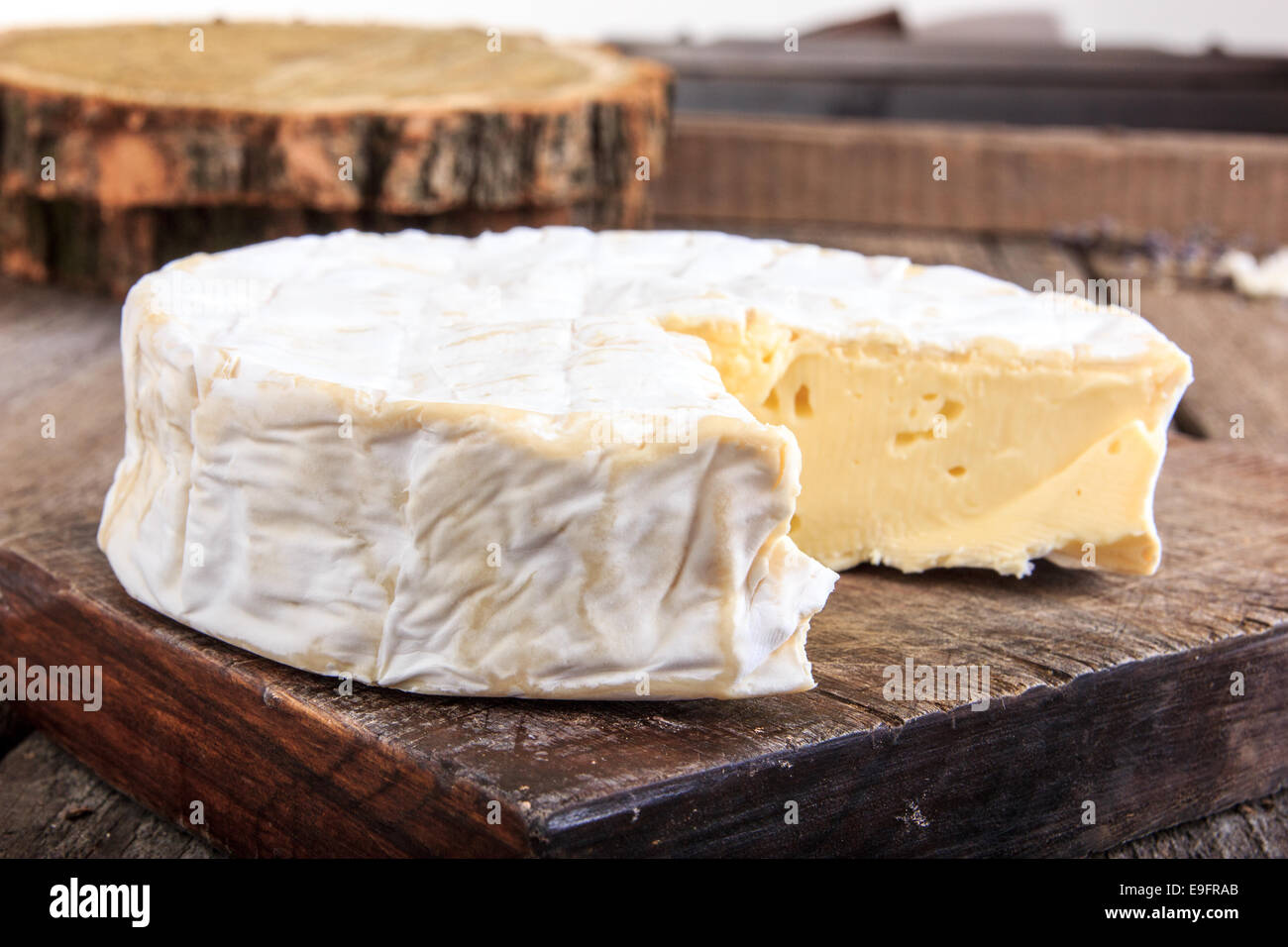 Round cheese wheel on wooden board without one slice Stock Photo - Alamy
