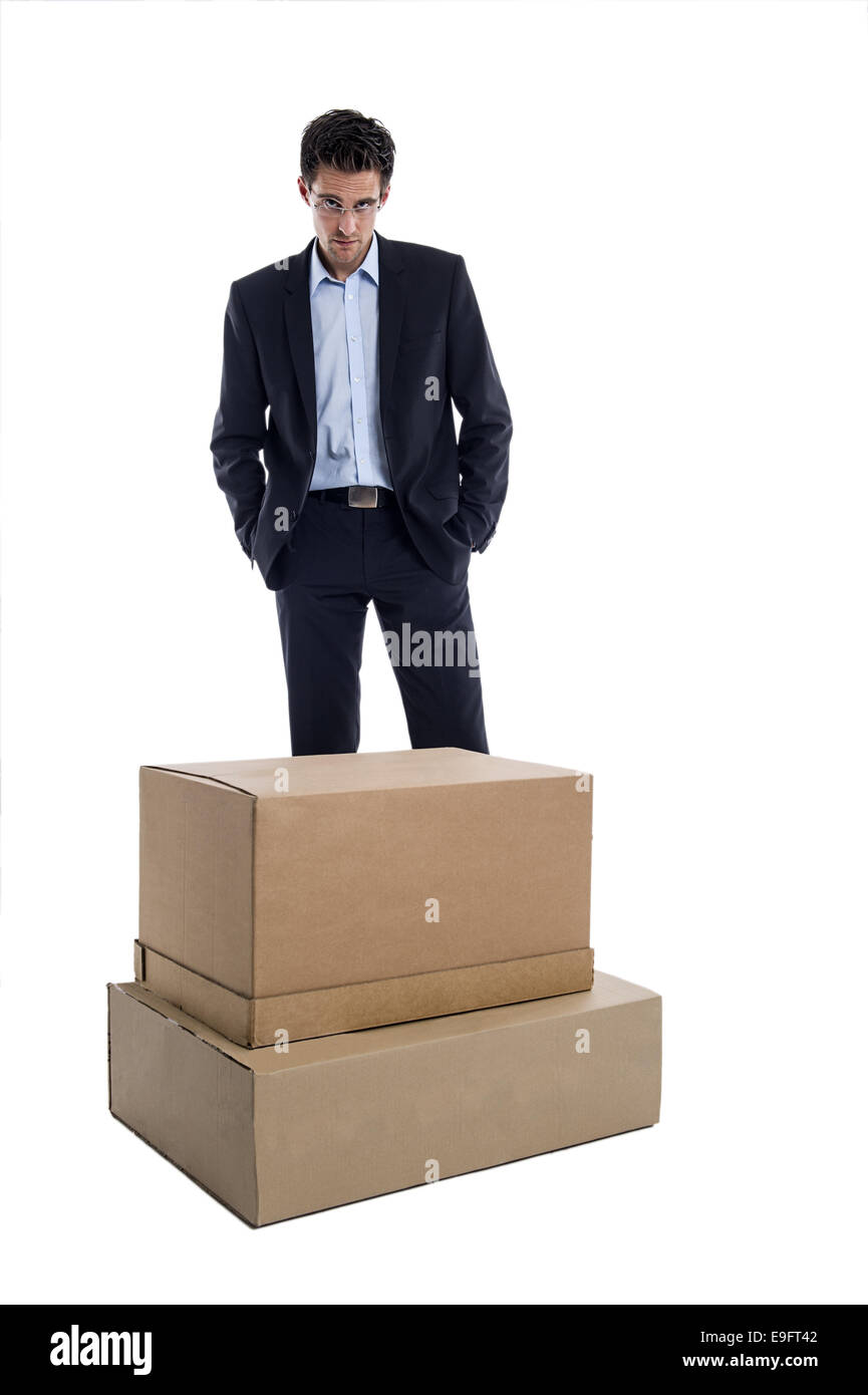 Pensive businessman in front of a box Stock Photo - Alamy