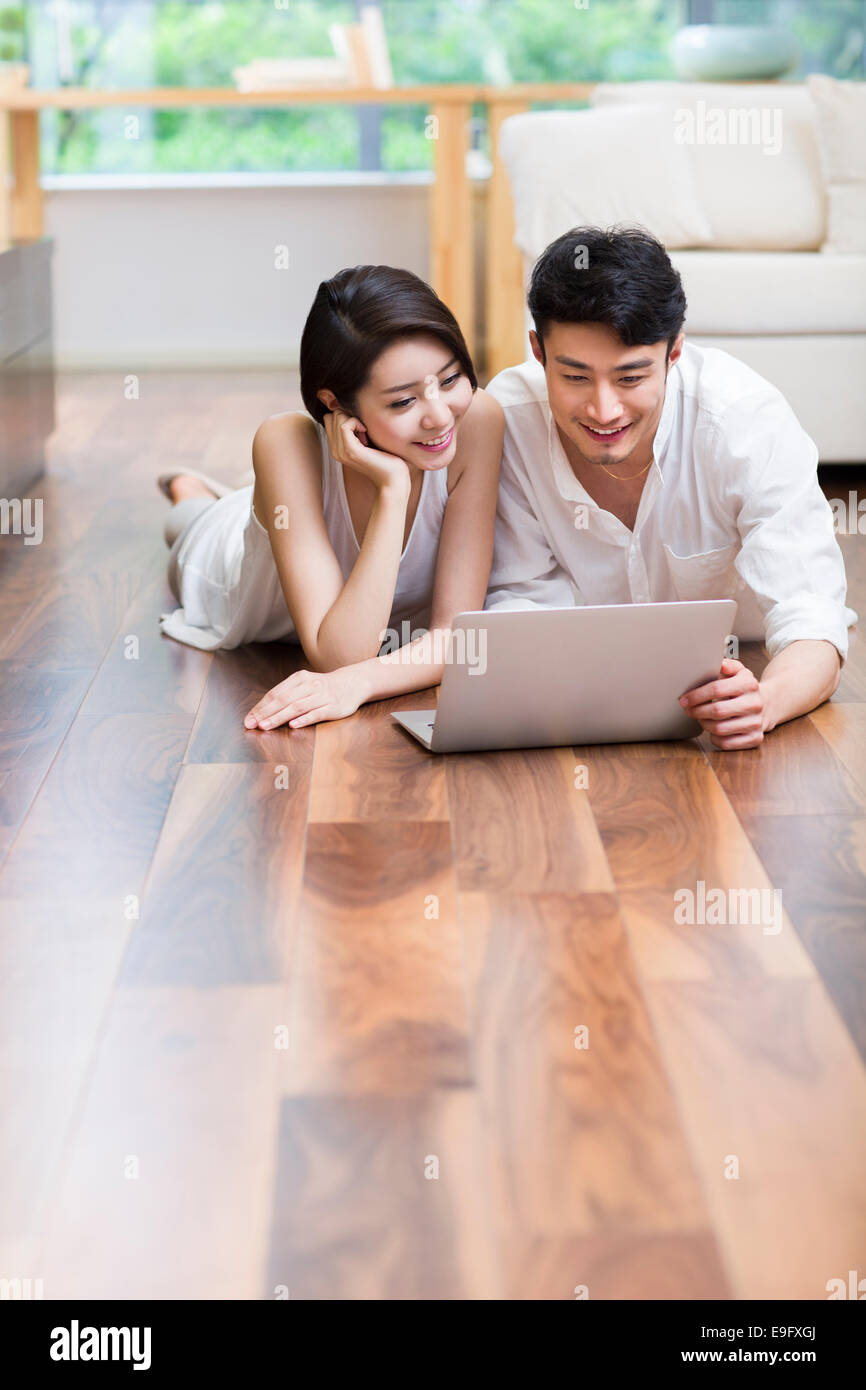Young couple lying on floor using laptop Stock Photo - Alamy
