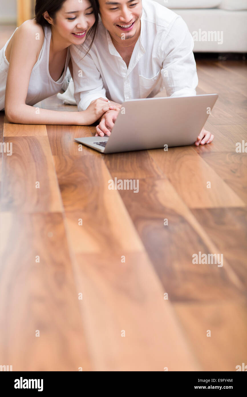 Young couple lying on floor using laptop Stock Photo - Alamy