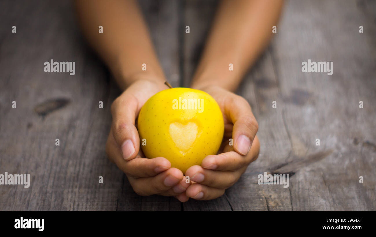 Yellow Apple with engraved heart Stock Photo - Alamy