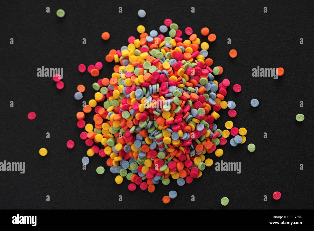 Multicolor sprinkles on black background Stock Photo - Alamy