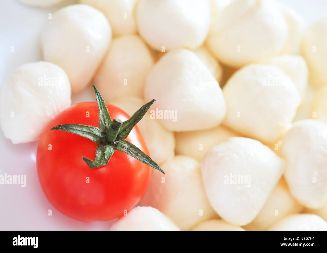 Mozzarella cheese and one cherry tomato Stock Photo - Alamy