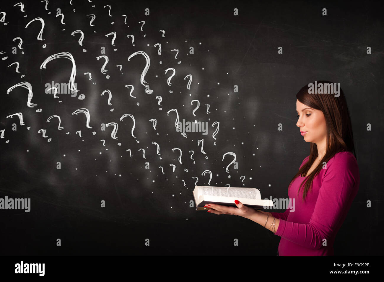 Pretty woman reading a book with question marks coming out from it ...