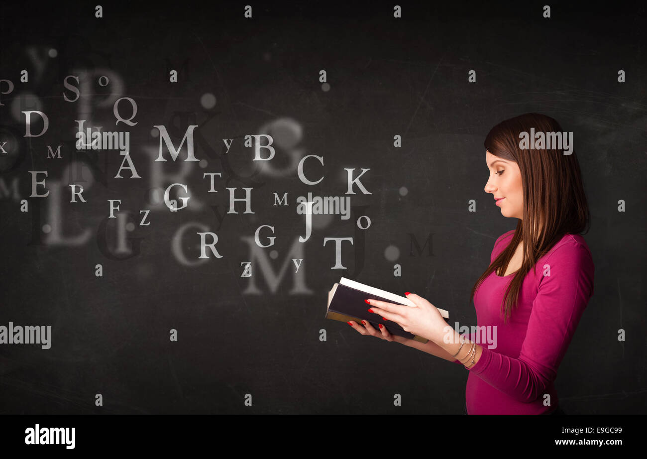 Young lady reading a book with alphabet letters Stock Photo - Alamy