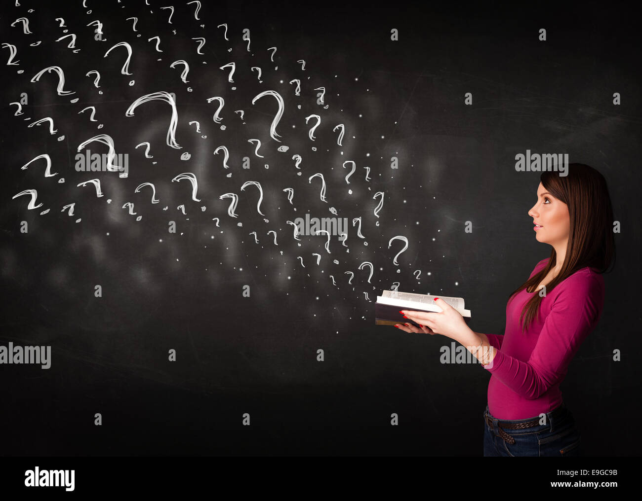 Pretty woman reading a book with question marks coming out from it ...
