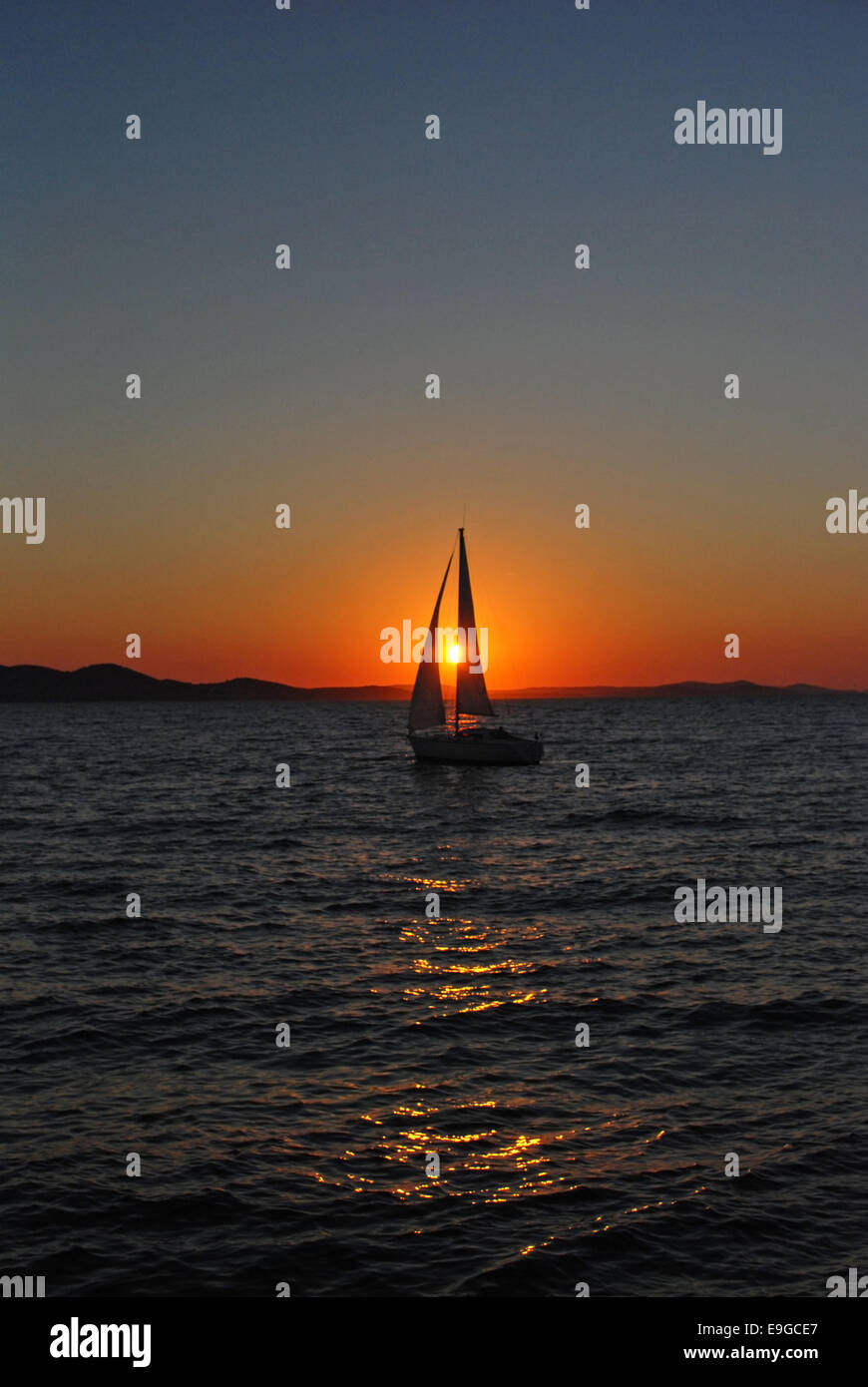 Sailing ship sails into the sunset Stock Photo - Alamy