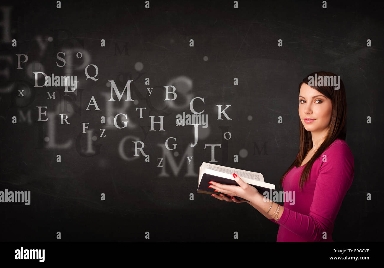 Young lady reading a book with alphabet letters Stock Photo - Alamy