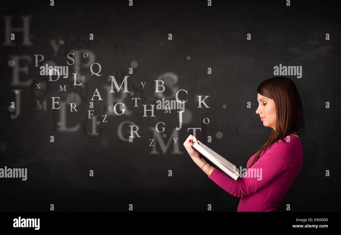 Young lady reading a book with alphabet letters Stock Photo - Alamy