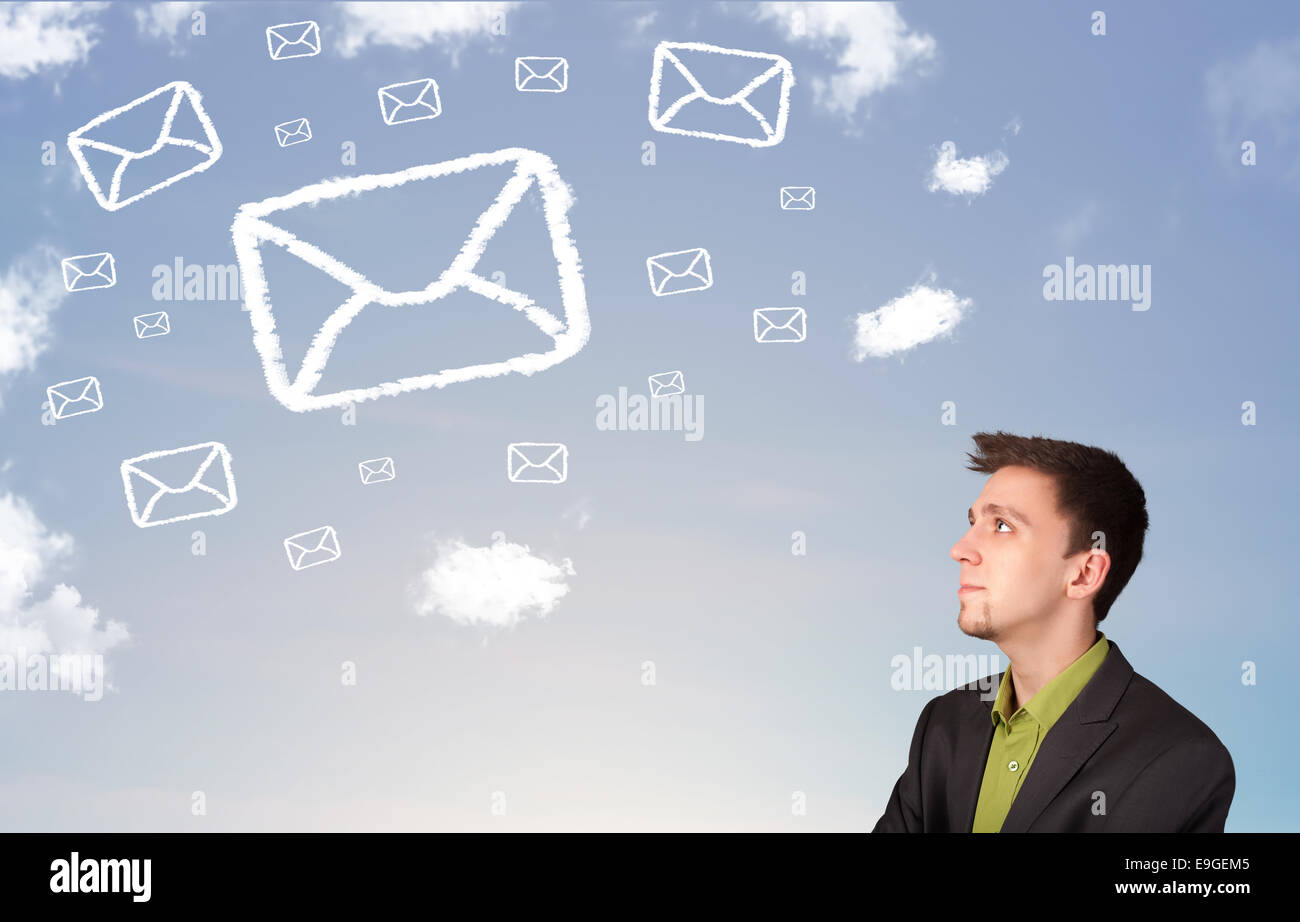 Businessman looking at mail symbol clouds on blue sky Stock Photo - Alamy