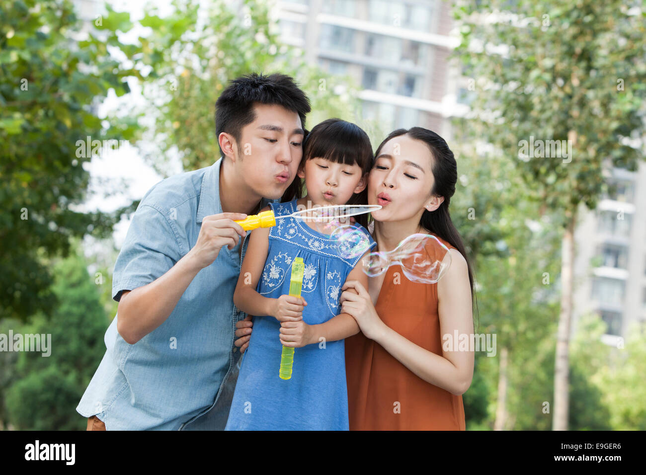 Happy young family blowing bubbles Stock Photo - Alamy