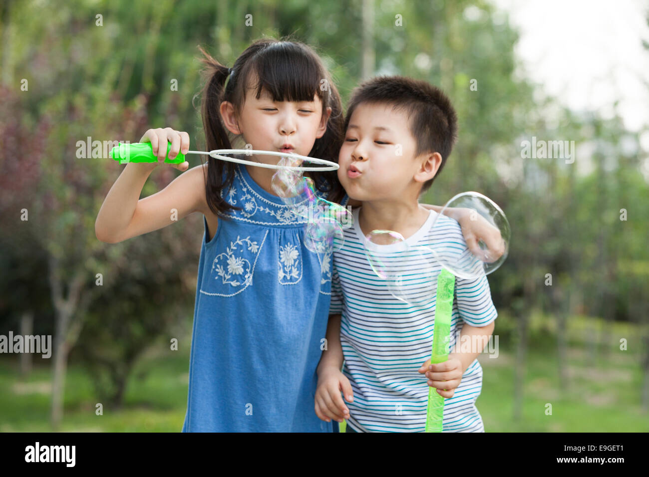 Two children blowing bubbles Stock Photo - Alamy