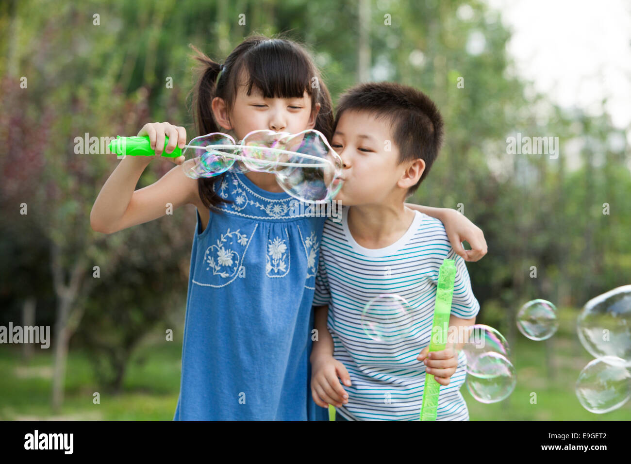 Two children blowing bubbles Stock Photo - Alamy