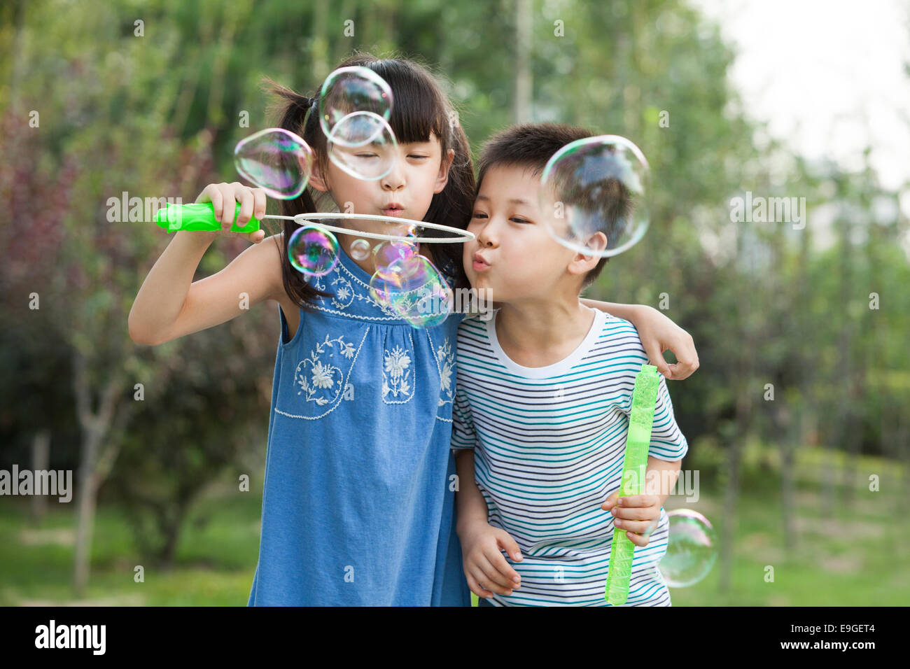 Two children blowing bubbles Stock Photo - Alamy