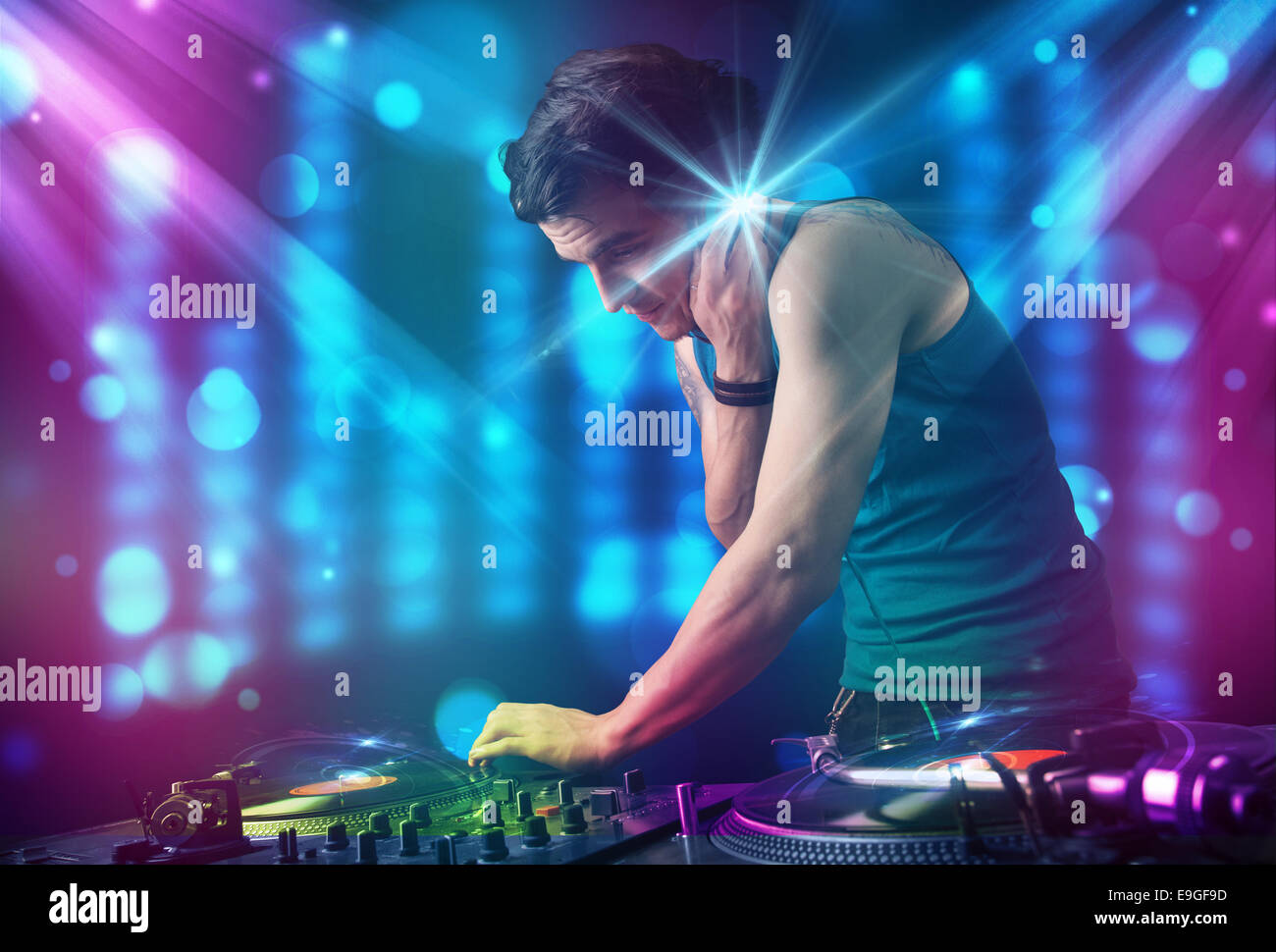 Dj mixing music in a club with blue and purple lights Stock Photo - Alamy