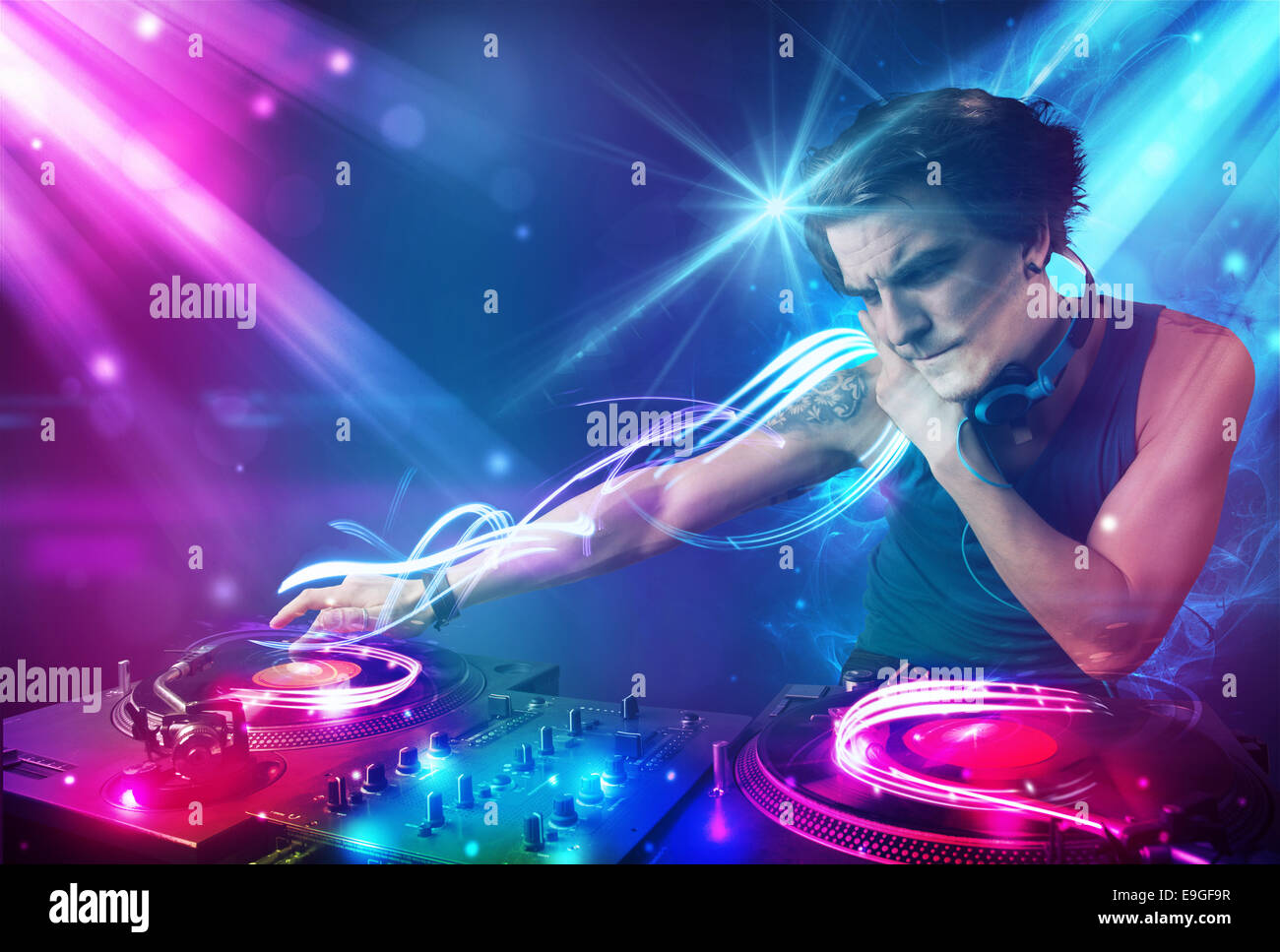 Energetic Dj mixing music with powerful light effects Stock Photo - Alamy