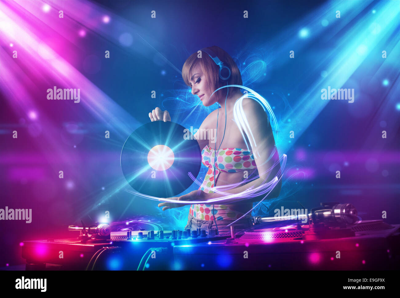 Energetic Dj girl mixing music with powerful light effects Stock Photo ...