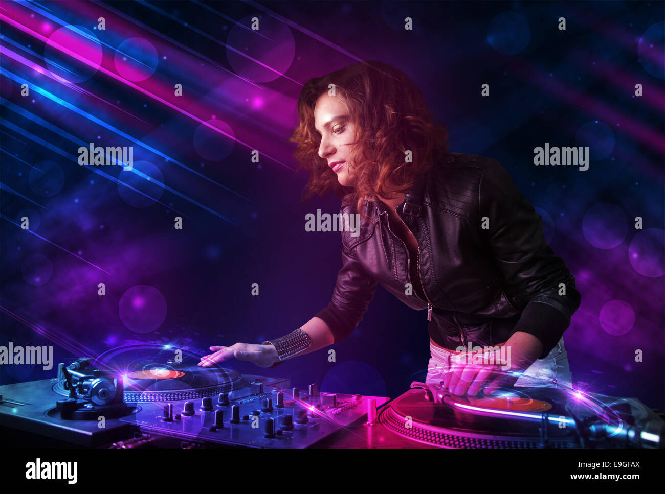 Young DJ playing on turntables with color light effects Stock Photo - Alamy